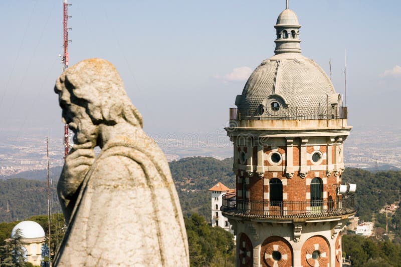 A Statue Standing by a Clock Tower in the Middle of Town Stock Image ...