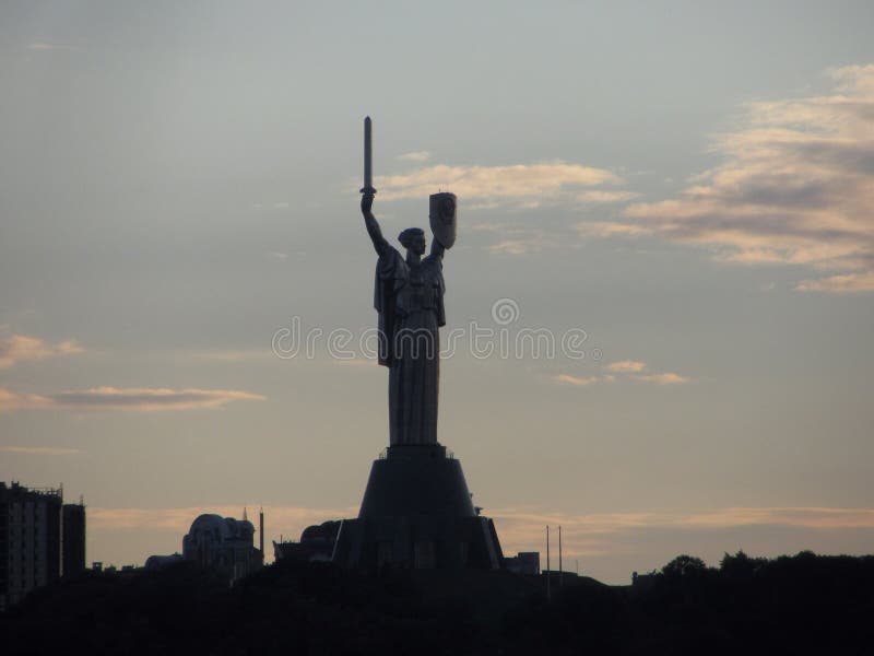 A Statue of a Standing Figure Against a Sunset Sky, Holding a Staff and ...