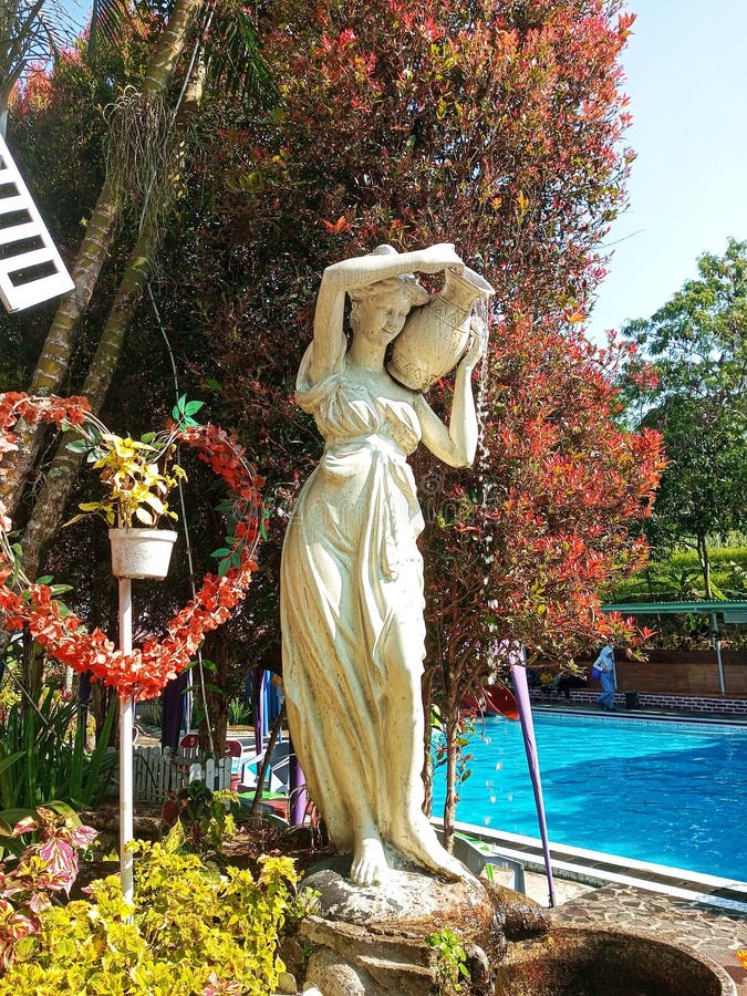 A Statue of a Woman Carrying Water in a Jug and the Water Falls Stock ...