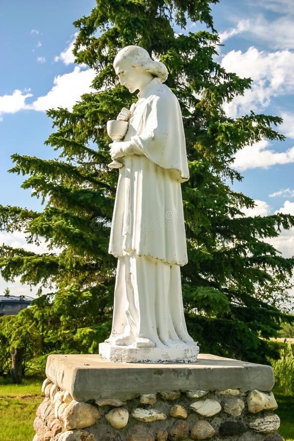 A Statue of a Woman Holding a Cup is Standing in Front of a Tree Stock ...