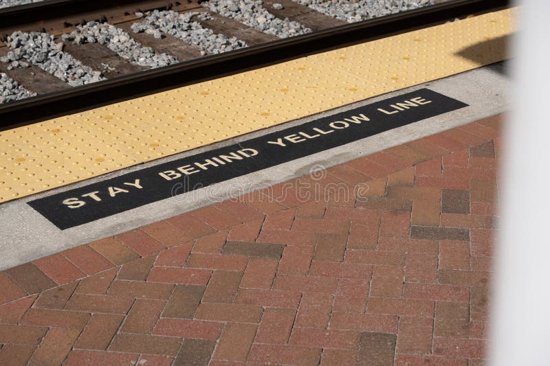 Stay Behind Yellow Line Safety Warning at Train Station Platform Stock ...