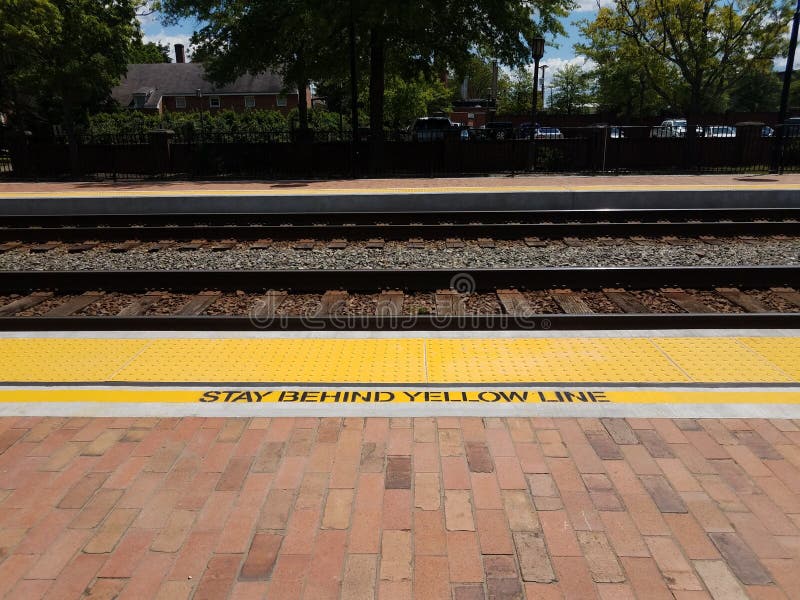 Stay Behind Yellow Line Sign and Train Tracks Stock Image - Image of ...