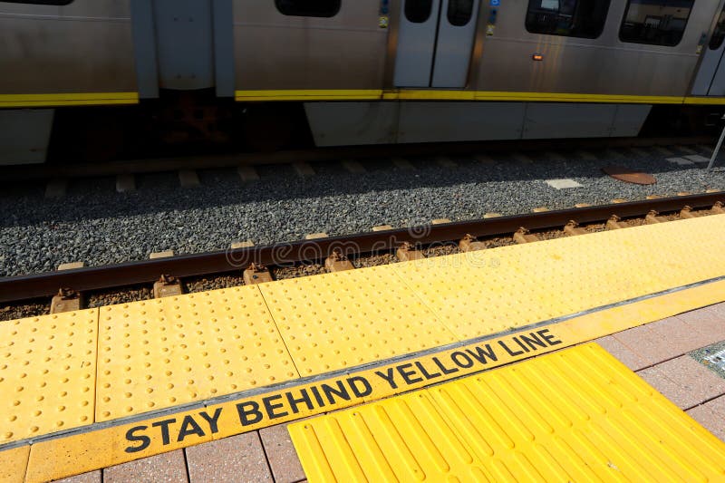 Stay Behind Yellow Line Warning Sign on Platform at Train Station Stock ...