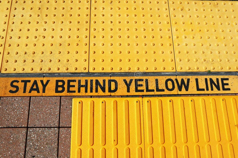 Stay Behind Yellow Line Warning Sign on Platform at Train Station Stock ...