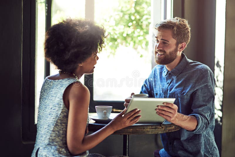 Staying Connected. Two People Using a Digital Tablet in a Cafe. Stock ...