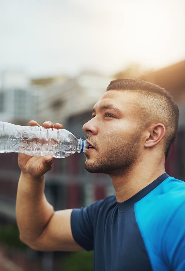 Staying Hydrated. a Young Man Drinking from His Water Bottle while Out ...