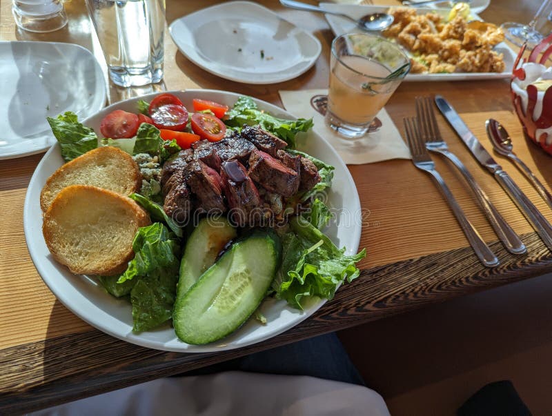 Steak Salad and Drinks on a Dinner Table in a Restaurant Stock Photo ...