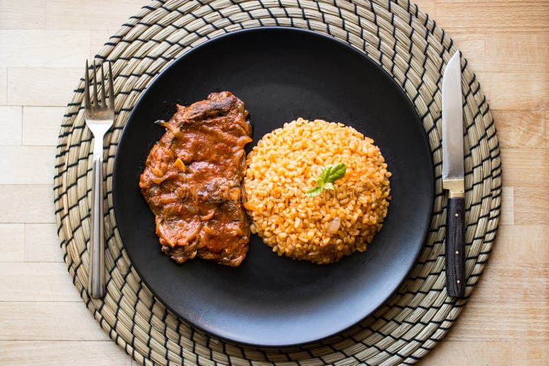 Steak with Tomato Sauce and Bulgur Rice in a Black Plate. Stock Photo ...