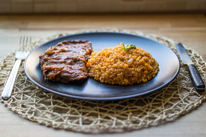 Steak with Tomato Sauce and Bulgur Rice in a Black Plate. Stock Image ...