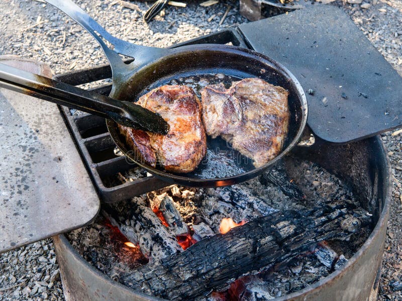 Steaks Sizzling on a Campfire Grill Stock Photo - Image of searing ...