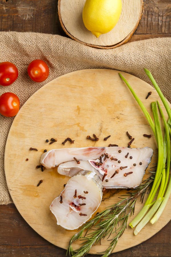 Steaks of Fresh White Cod Fish on a Round Board Sprinkled with Spices ...