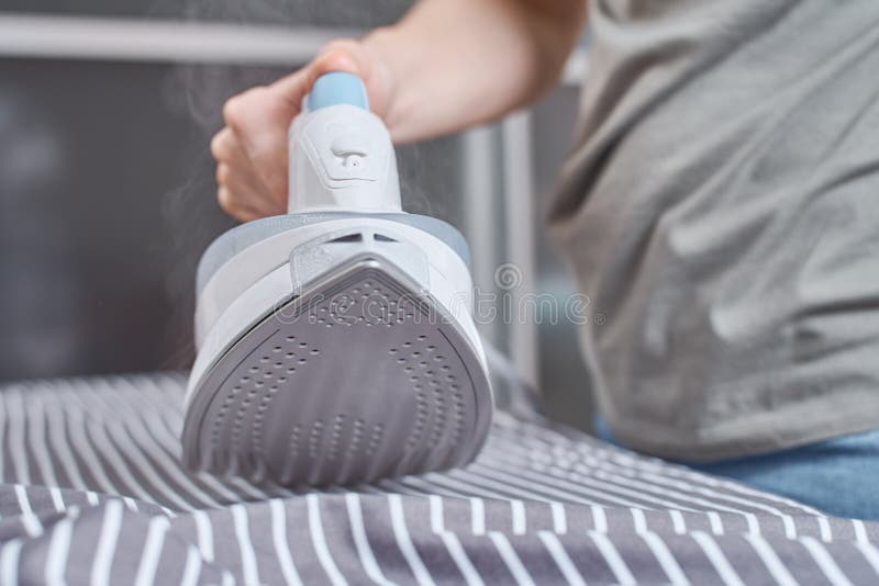 Steam Boost on the Modern Iron. Woman Ironing Clothes with Modern Iron ...