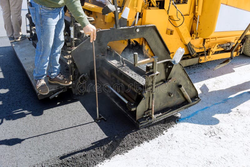 A Steam Roller and an Asphalt Paver Machine are Used during the ...