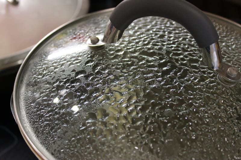 Steam Turns into Water Droplets on the Inside of a Glass Lid of a ...