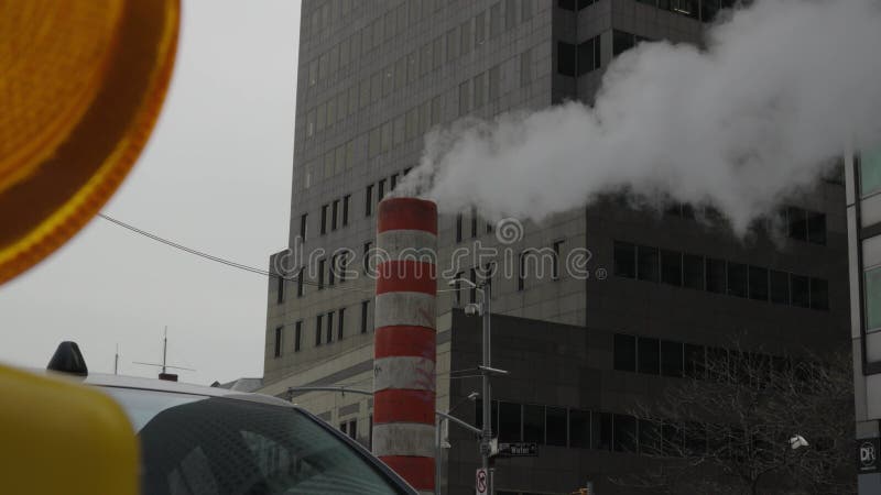 Steam Vents from an Orange and White Construction Pipe with an Office ...