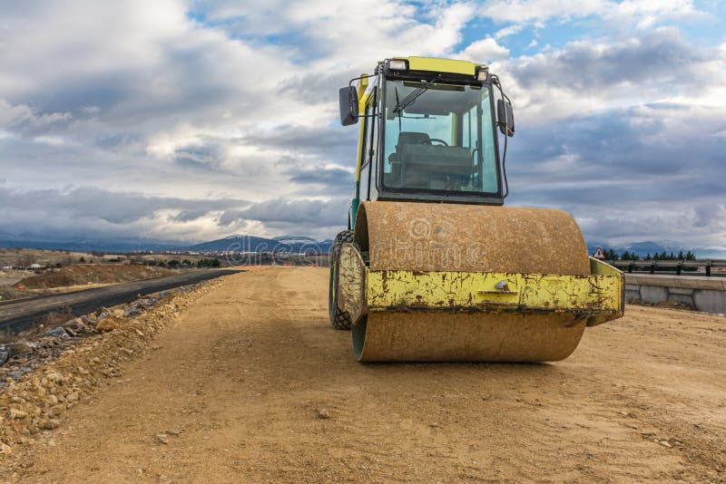 Yellow Steamroller Performing Ground Leveling Work Stock Photo - Image ...