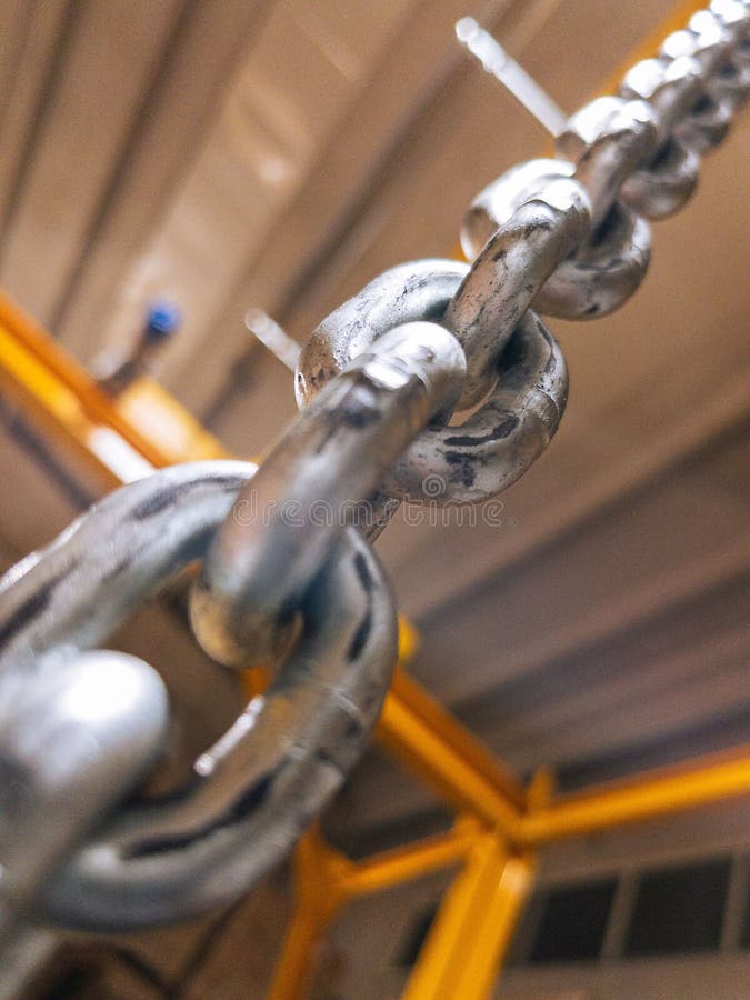 Steel Chain Suspended from Mechanical Crane in an Industrial Setting ...