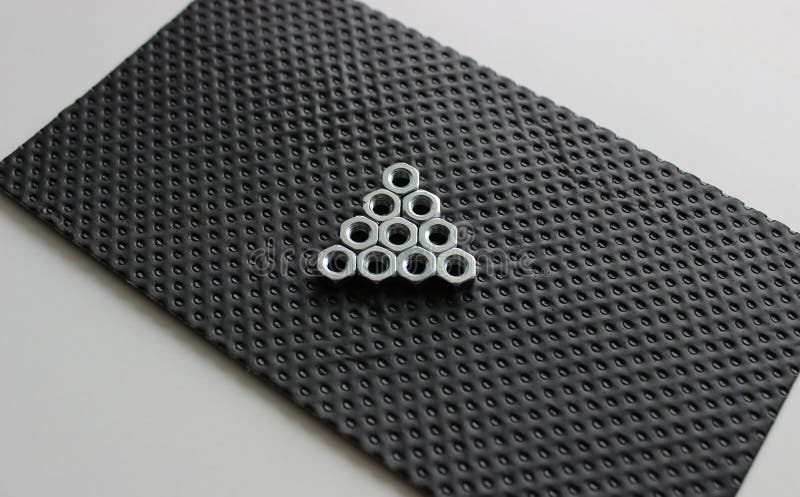 Steel Nuts in Play Button Shape on Black Rubberized Panel Stock Image ...