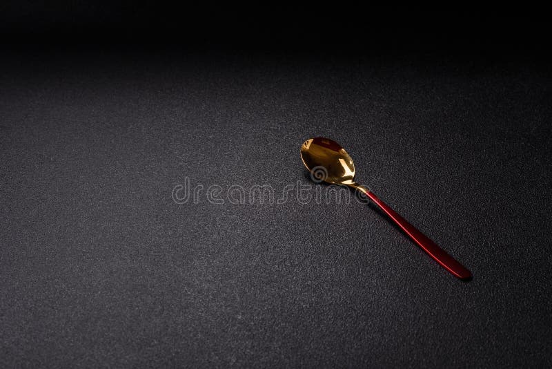 Steel Spoon or Teaspoon with Red Handle on Dark Concrete Background ...