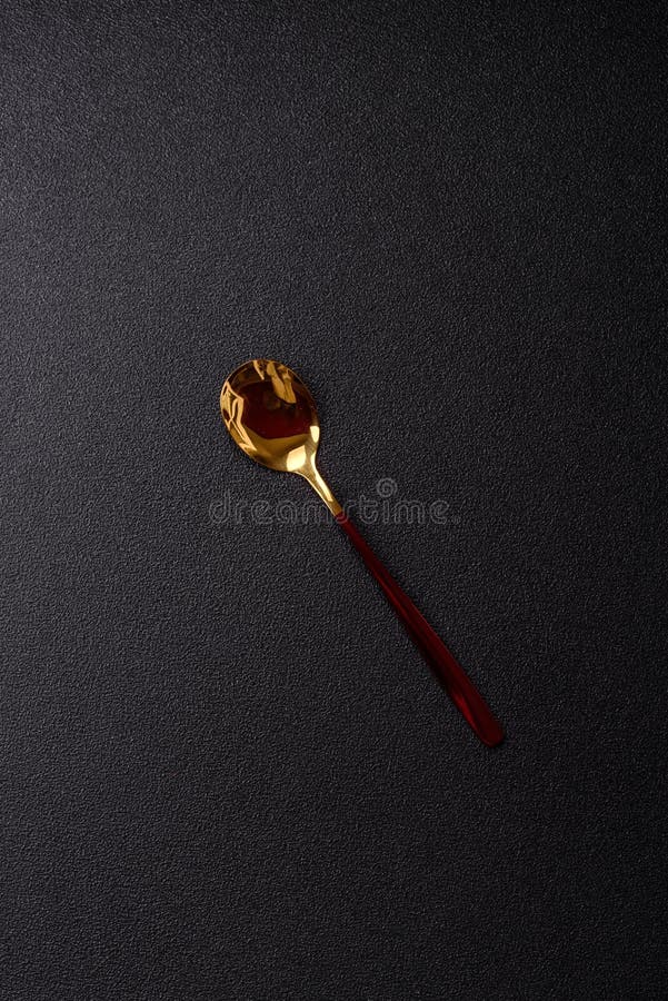 Steel Spoon or Teaspoon with Red Handle on Dark Concrete Background ...