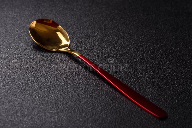 Steel Spoon or Teaspoon with Red Handle on Dark Concrete Background ...