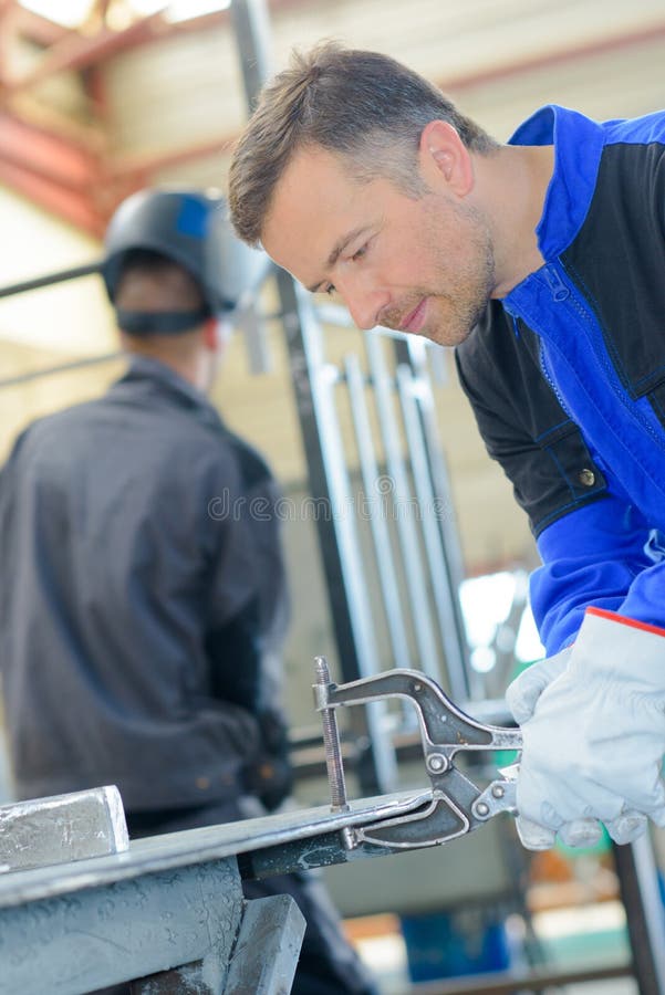 Steel worker using clamp stock image. Image of factory - 118890979