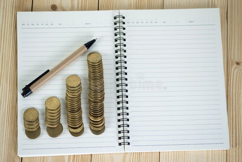Steps of Coins Stack with Notebook Paper on Wooden Working Table with ...