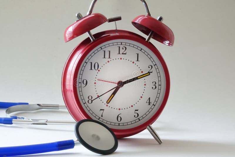 A Clock Sitting Next To a Stethoscope on a White Table Stock Image ...