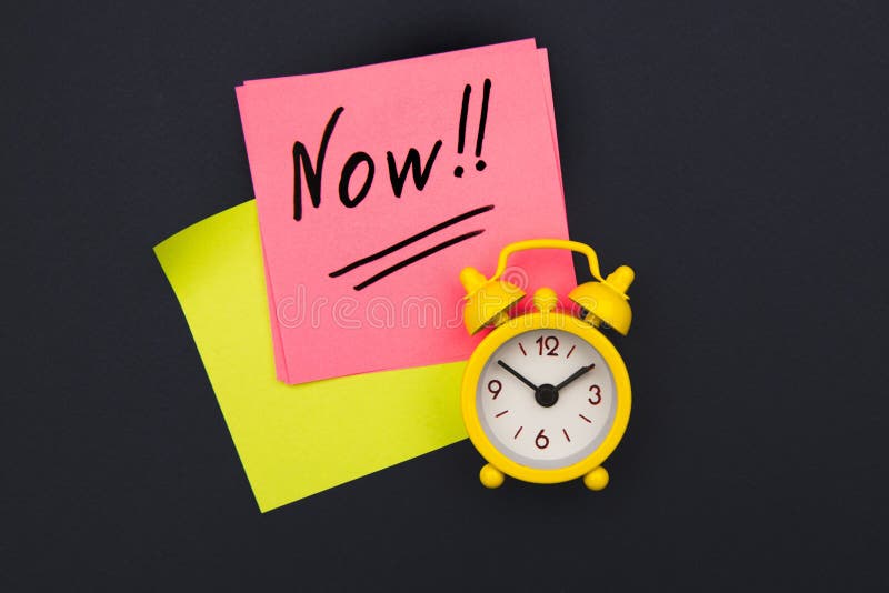 Sticker with Handwriting the Word NOW on Alarm Clock on Dark Blue ...