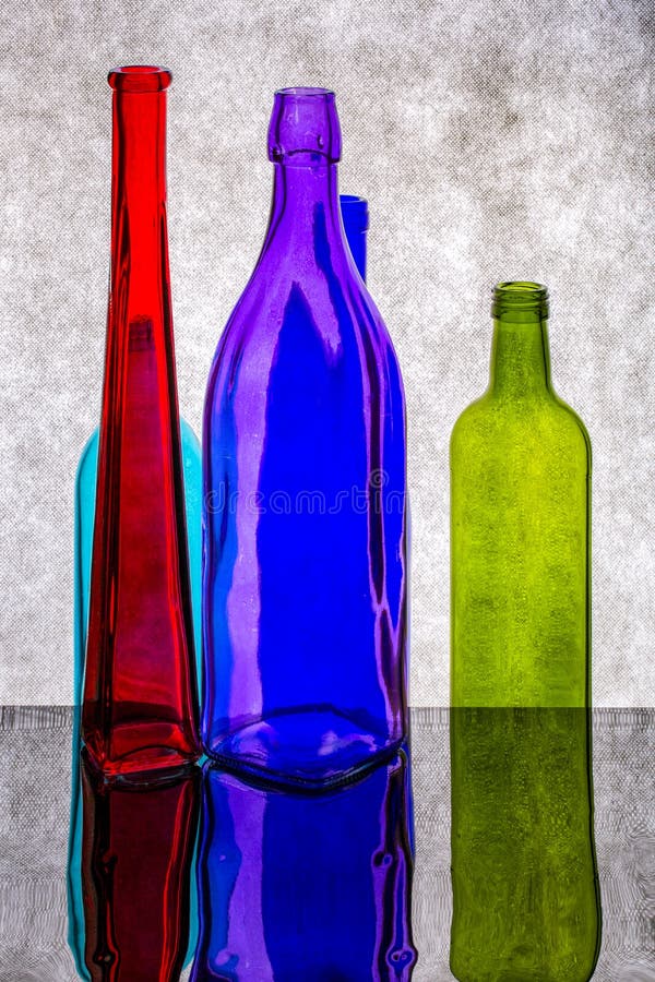Still Life with Colored Bottles on a Reflective Surface Stock Photo ...