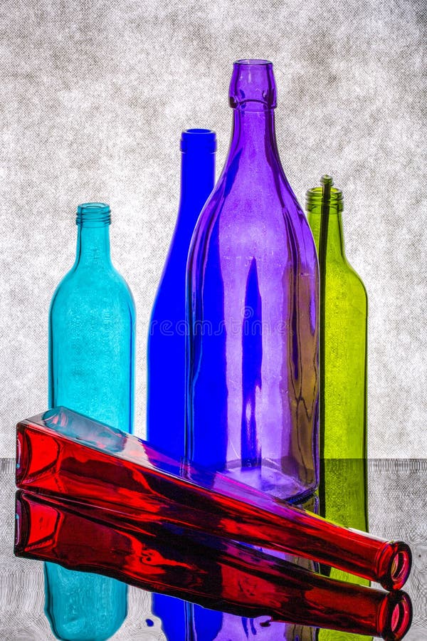 Still Life with Colored Bottles on a Reflective Surface Stock Photo ...