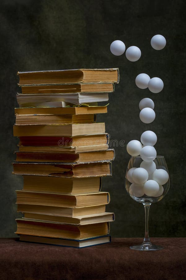 Still Life with a Stack of Books and White Balls in a Glass Stock Photo ...