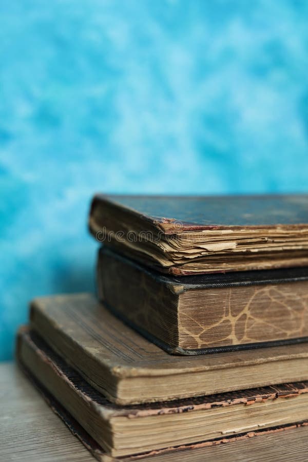 Stack of Old Books on a Wooden Table with Blue Wall Background. Stock ...