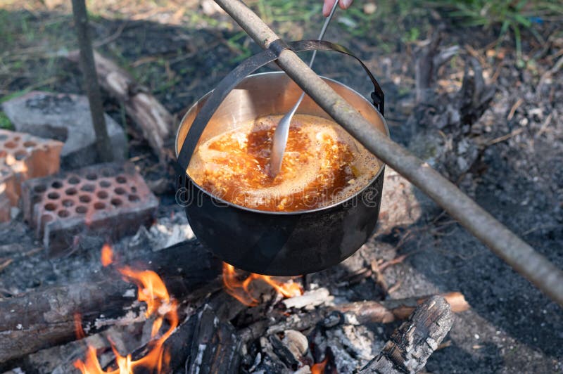 Stir the Dish Over the Fire. Stir the Soup with a Spoon Stock Image ...