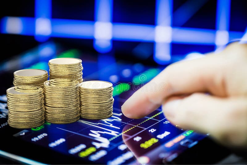 Stock Market Watching with Digital Tablet and Stack of Gold Coin Stock ...