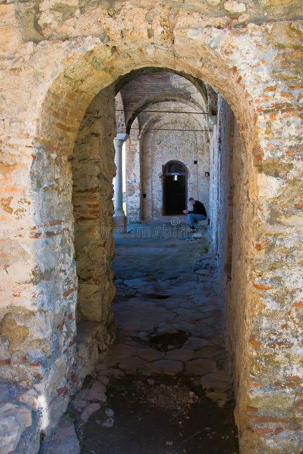 Stone-arched Walkway in an Ancient Building with a Group of Tourists in ...