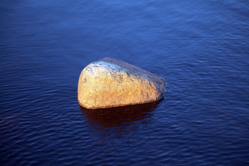 Stone on blue water stock photo. Image of water, stone - 21339614