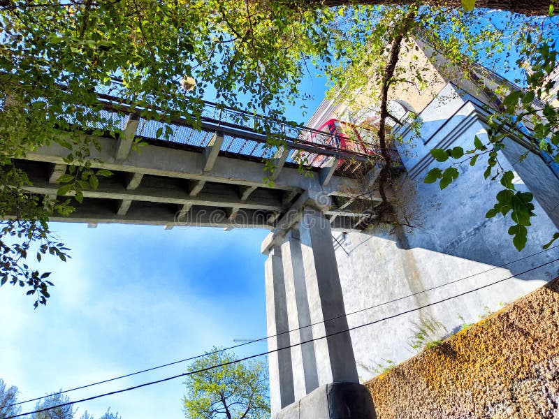 A Stone Bridge Arches Over a Road, with a Person Walking in the ...
