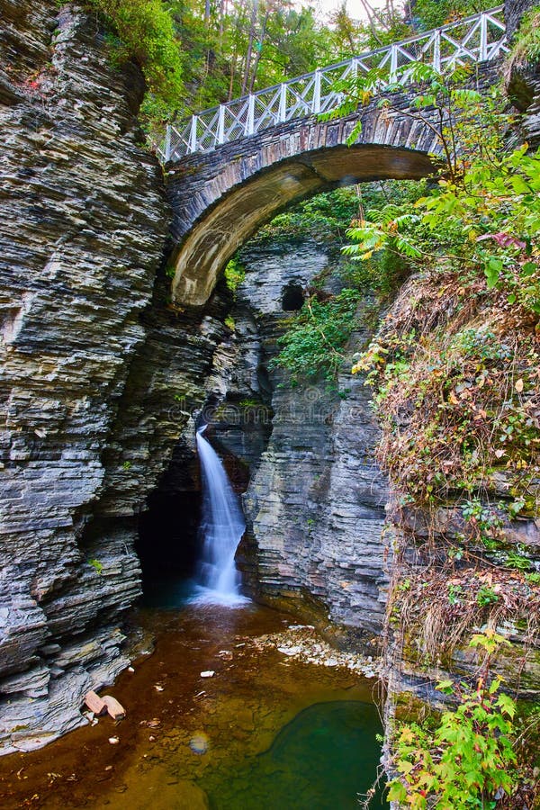Stone Bridge Crosses Over Waterfall in Deep Gorge with Layered Rocks ...