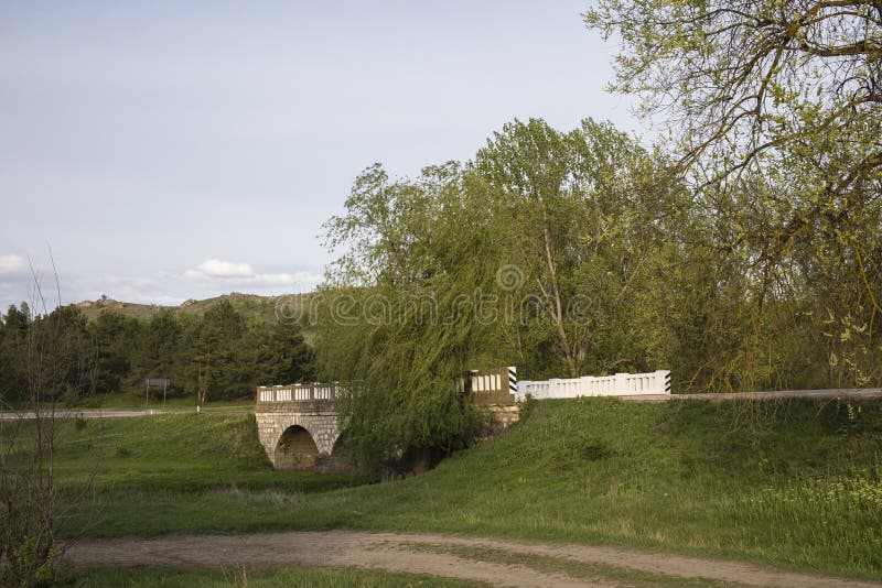 A Stone Bridge Over a Small River Flowing in Country Stock Image ...
