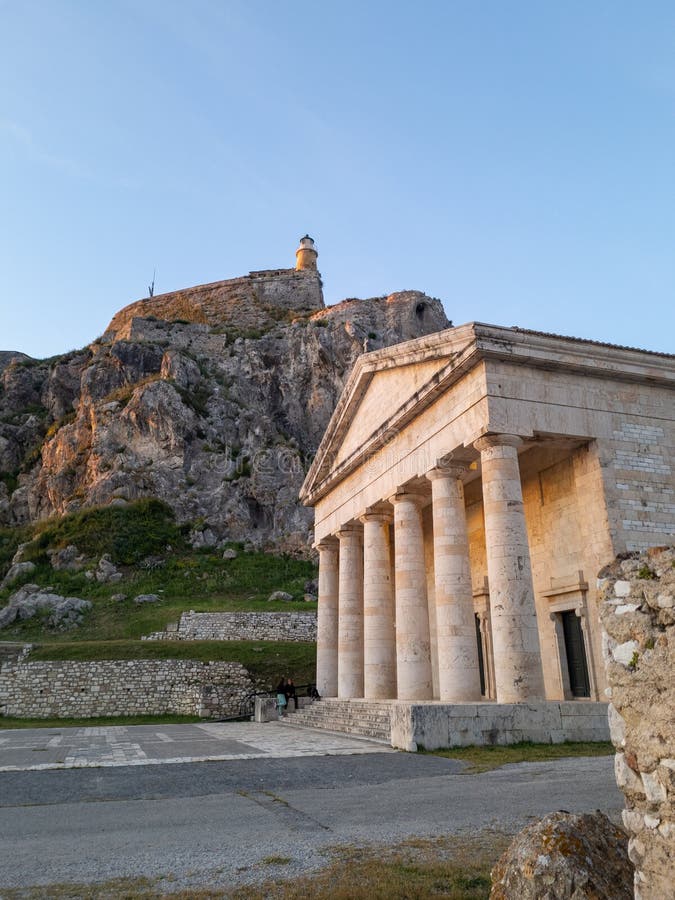 A Classical Stone Building with Columns Stands before a Rocky Hill ...