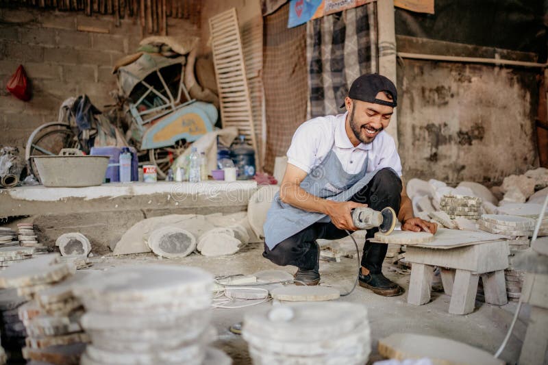 Stone Craft Worker Squats while Cutting Stones Using a Grinder Stock ...