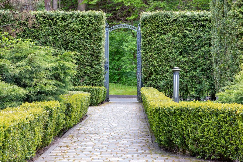 A Stone-lined Path Leads To the Exit To the Gate between Neatly Trimmed ...