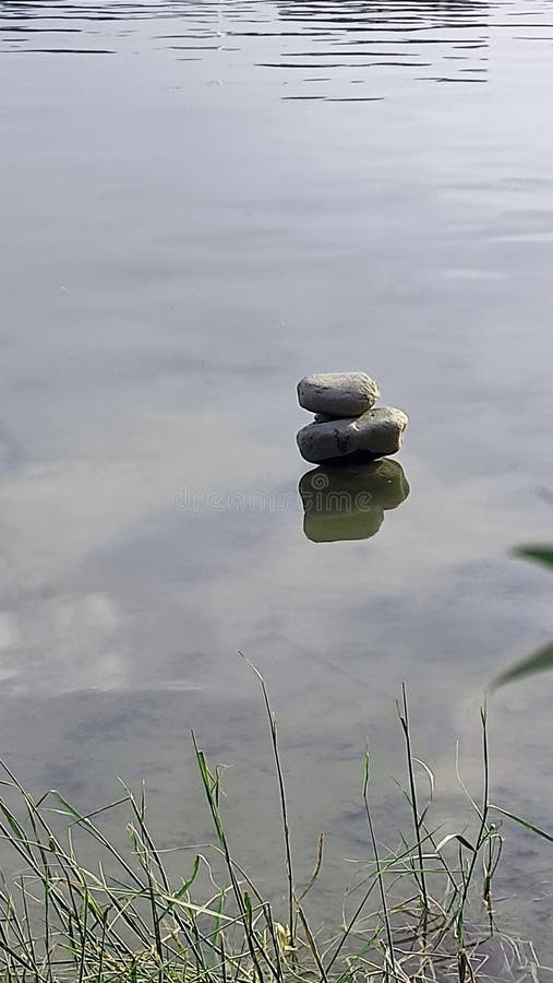 A Stone Lying on Another Stone on the Water Surface Stock Photo - Image ...