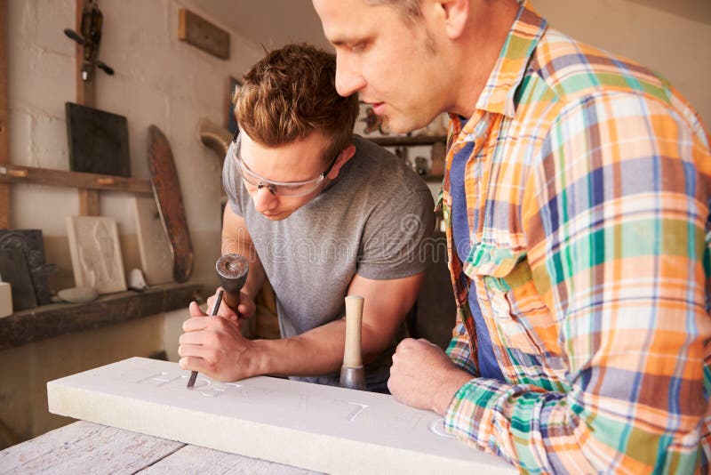 Stone Mason with Apprentice at Work on Carving in Studio Stock Image ...