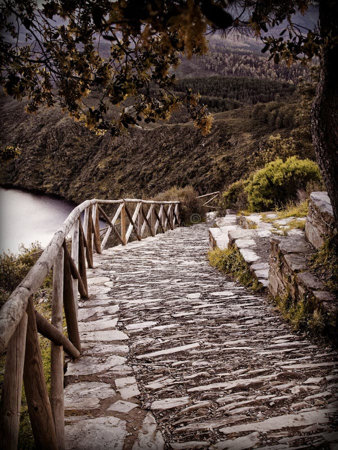 Stone Path Leads Down the Side of a Lake, Flanked by a Wooden Railing ...