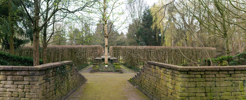 Stone Pathway Leading To a Central Tree Surrounded by Hedges and ...