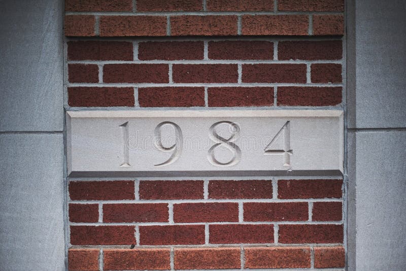 Stone Plaque with 1984 Engraving in Brick Wall Stock Photo - Image of ...