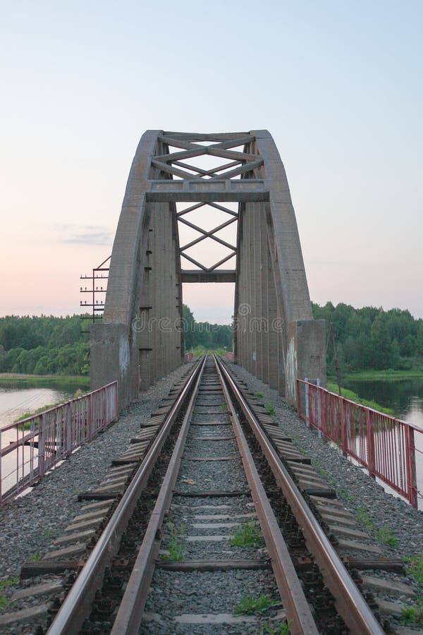 Stone Railway Bridge with Arches Over the Rails and the River at Sunset ...