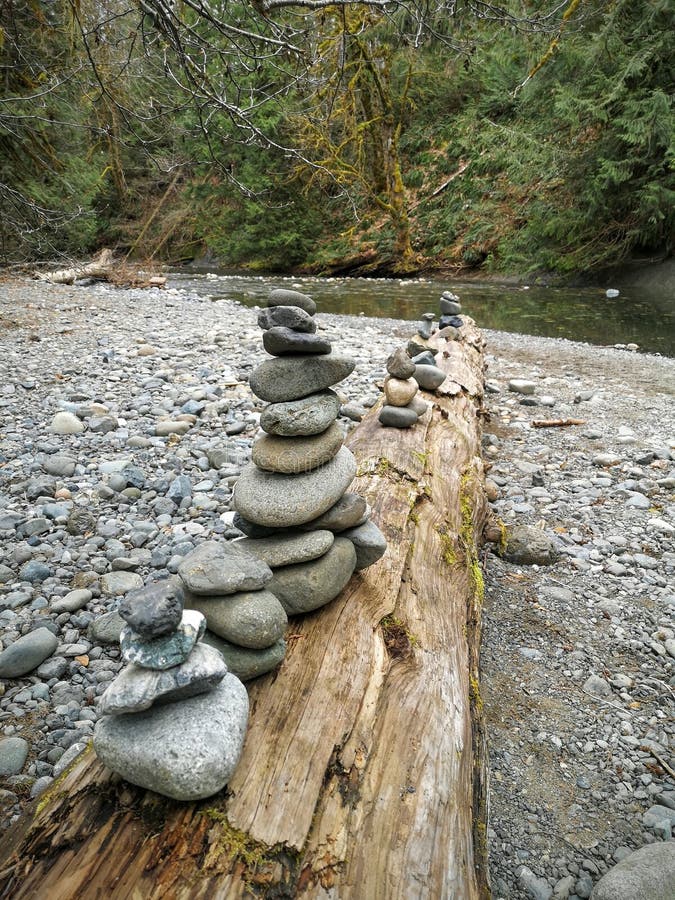 Stone Sculptures on a Log beside a River Stock Image - Image of ...